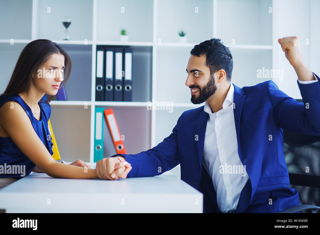 Side view portrait of man and woman armwrestling, exerting pressure on ...
