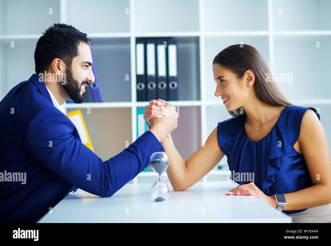 Side view portrait of man and woman armwrestling, exerting pressure on ...