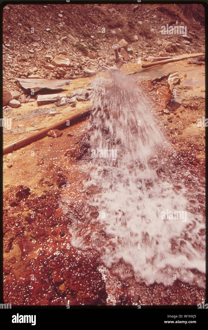 WATER FROM THIS PIPE IS PUSHED UP BY GAS FROM A DEEP WELL. THE RED ...