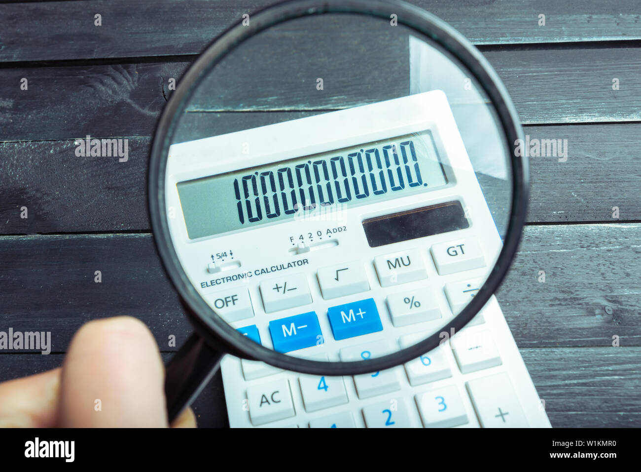 Calculator and magnifying glass Stock Photo - Alamy