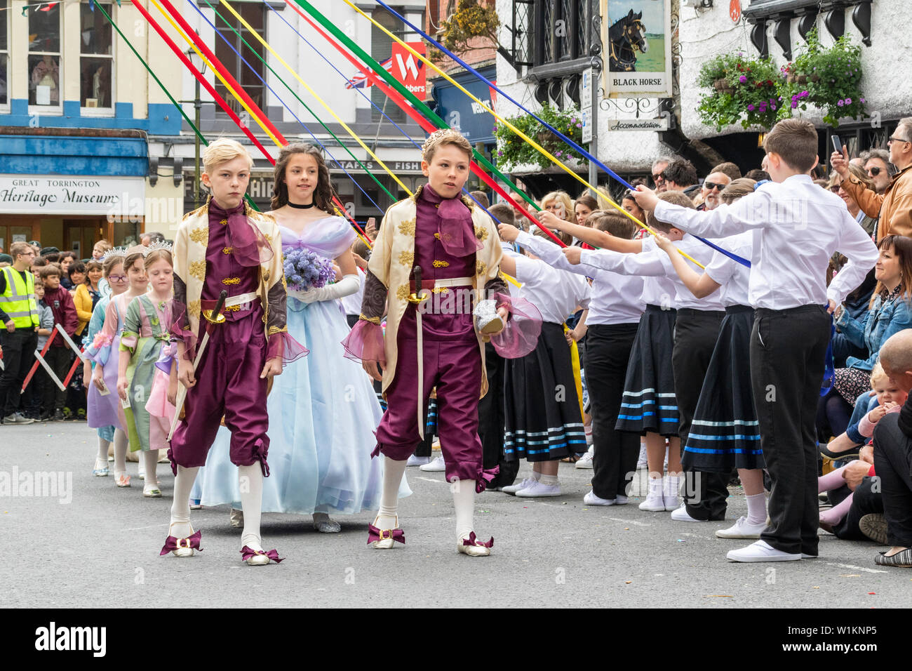 May Queen and Her Attendants Process Beneath the Maypole Ribbons in The ...