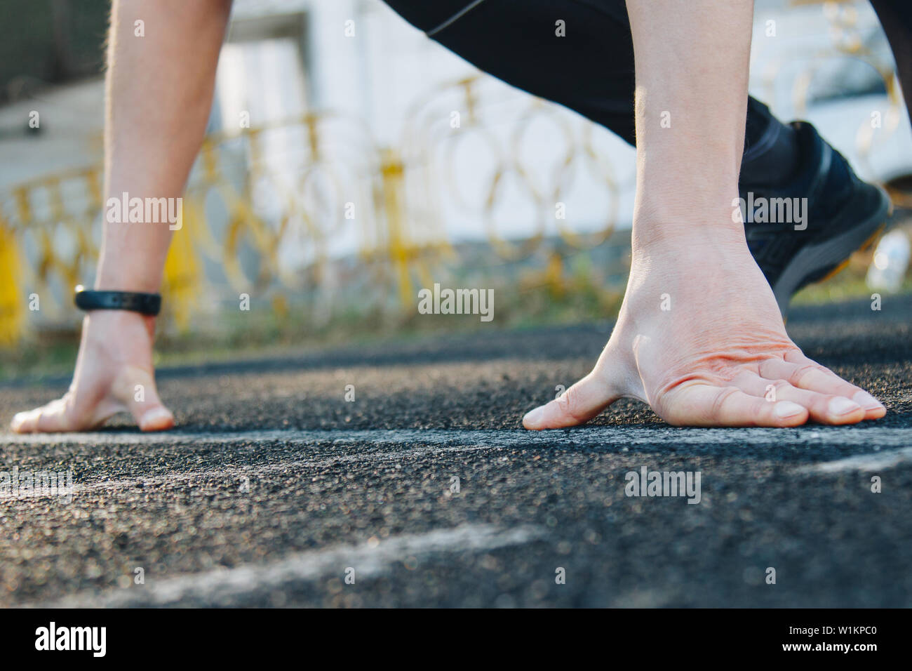 one runner on the starting line on the stadium track is waiting to ...