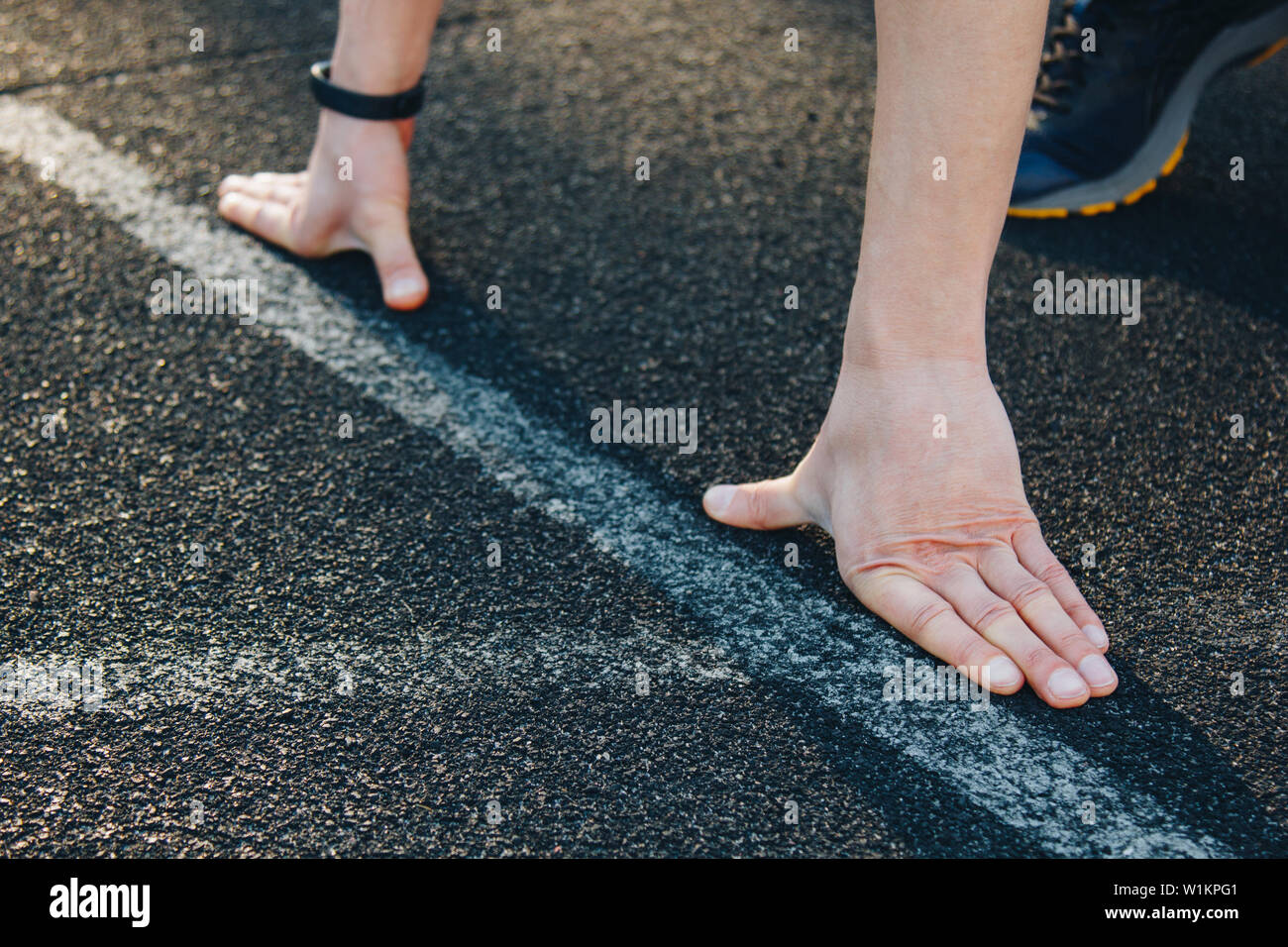 one runner on the starting line on the stadium track is waiting to ...