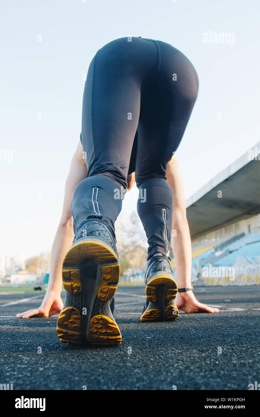 one man on the start line awaits the start of the sprint. stadium ...
