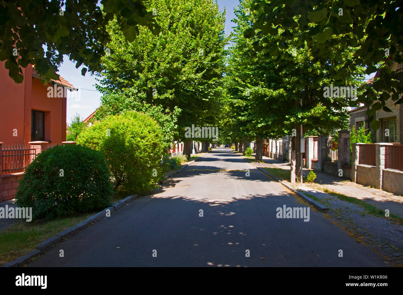 Sunny street view with red hiuses and trees in Kladno, Czech republic ...