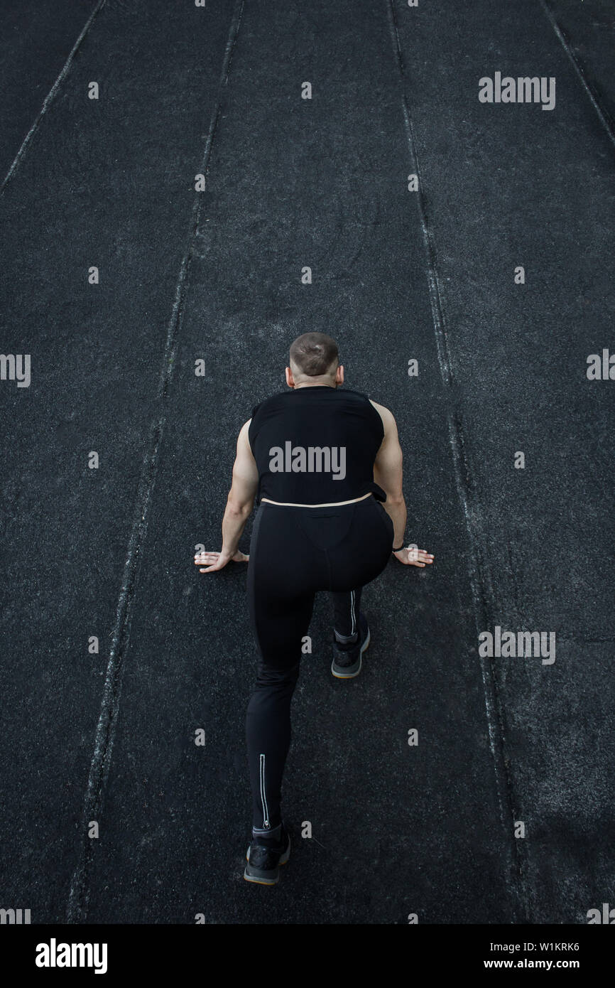 caucasian man doing a sprint start. running on the stadium on a track ...