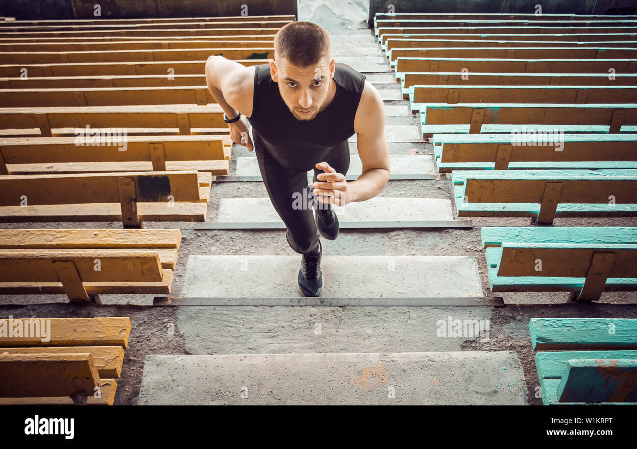 Caucasian man trains in running on the stairs. Track and field runner ...