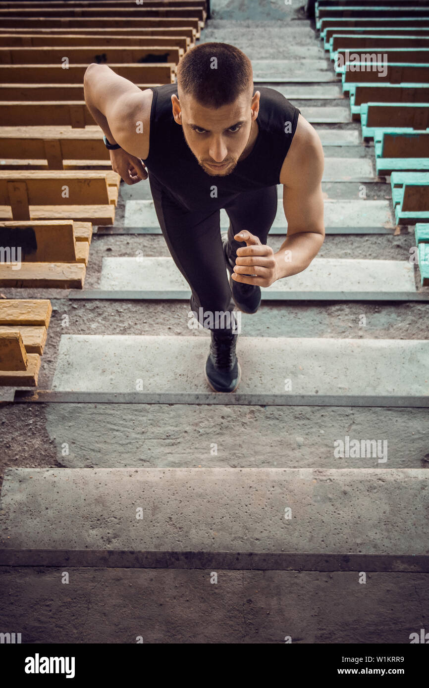 Caucasian man trains in running on the stairs. Track and field runner ...
