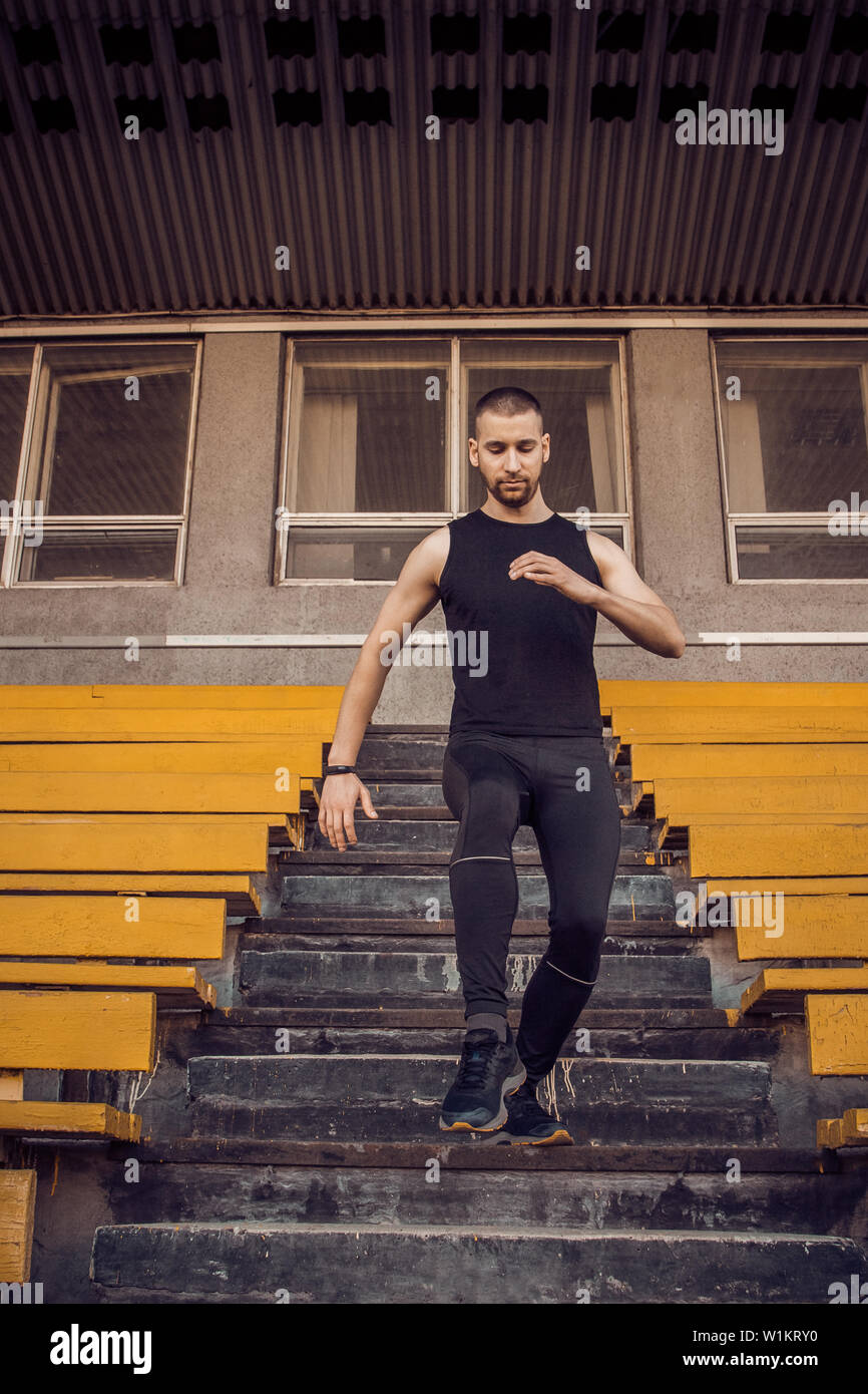 Caucasian man trains in running on the stairs. Track and field runner ...