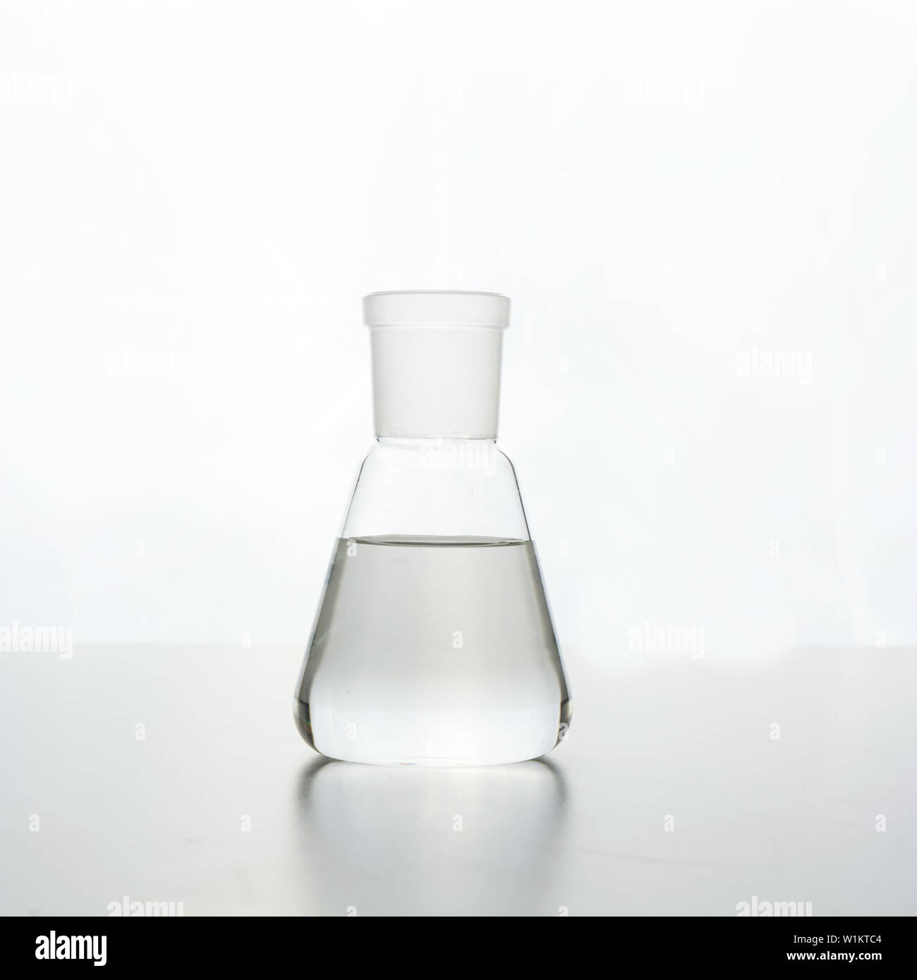 Chemistry flask with transparent white liquid for science research and ...