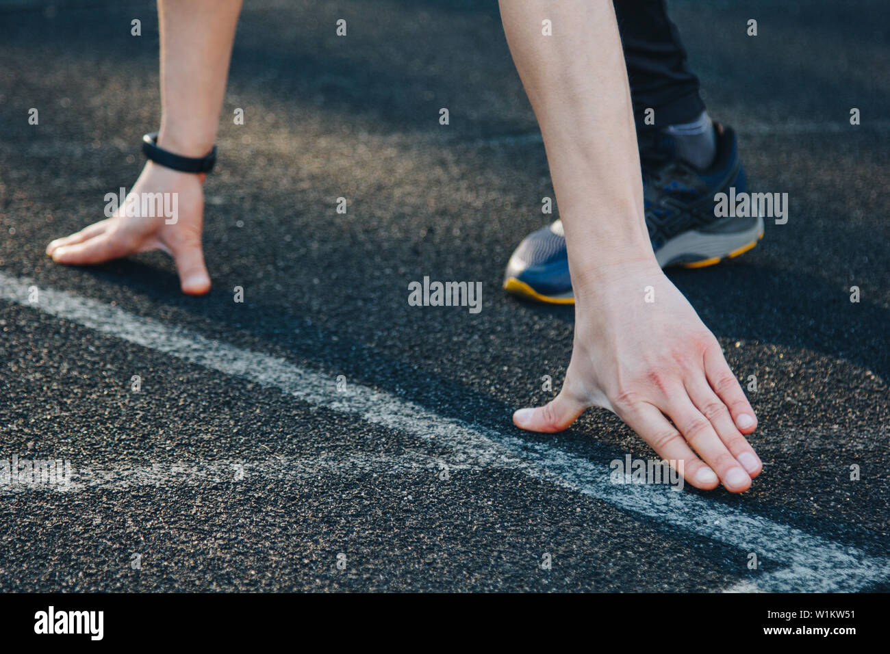 one runner on the starting line on the stadium track is waiting to ...