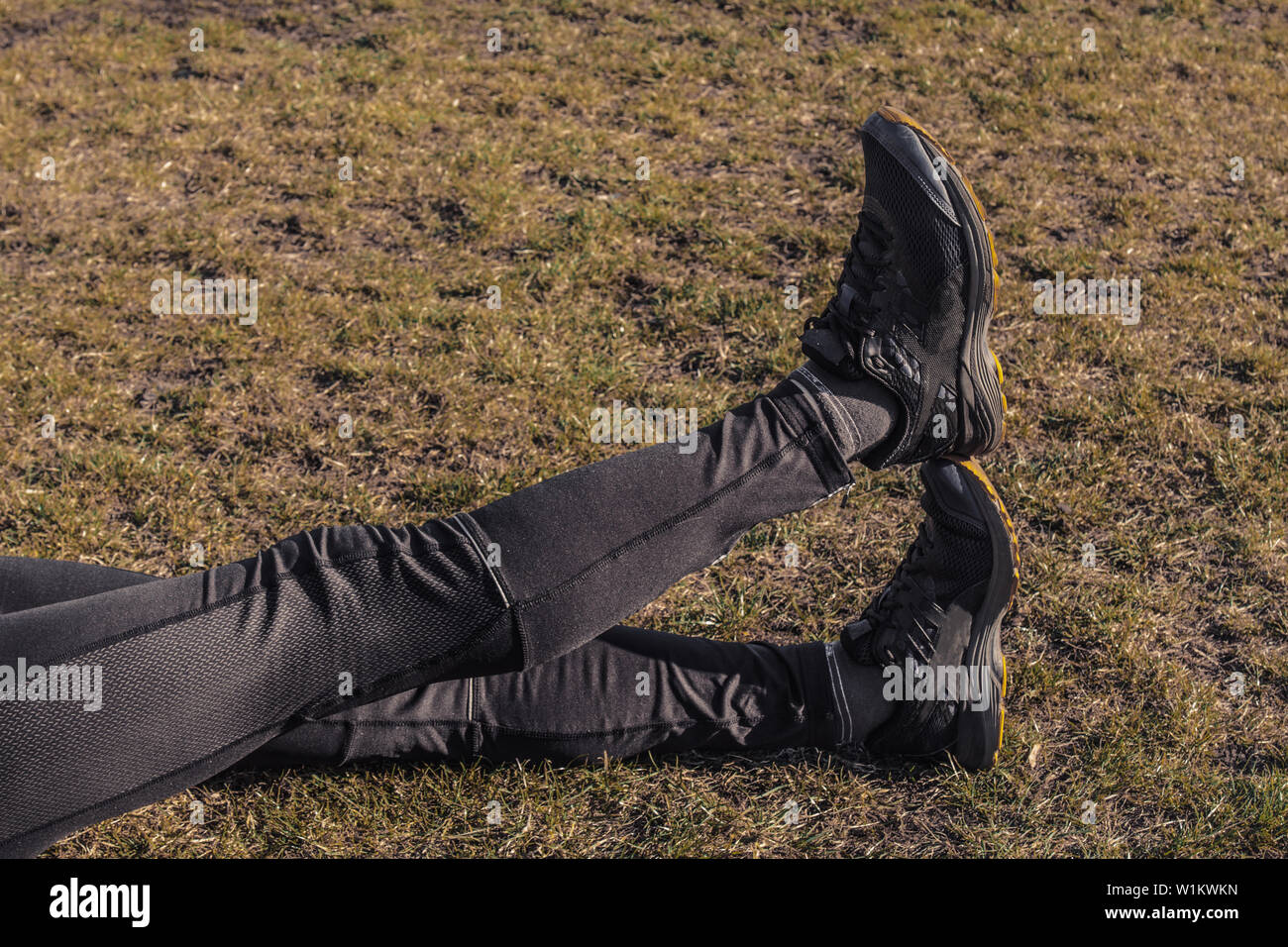 athlete's legs in leggings and sneakers, lying on the ground on the ...