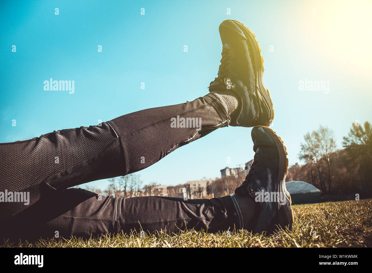 athlete's legs in leggings and sneakers, lying on the ground on the ...