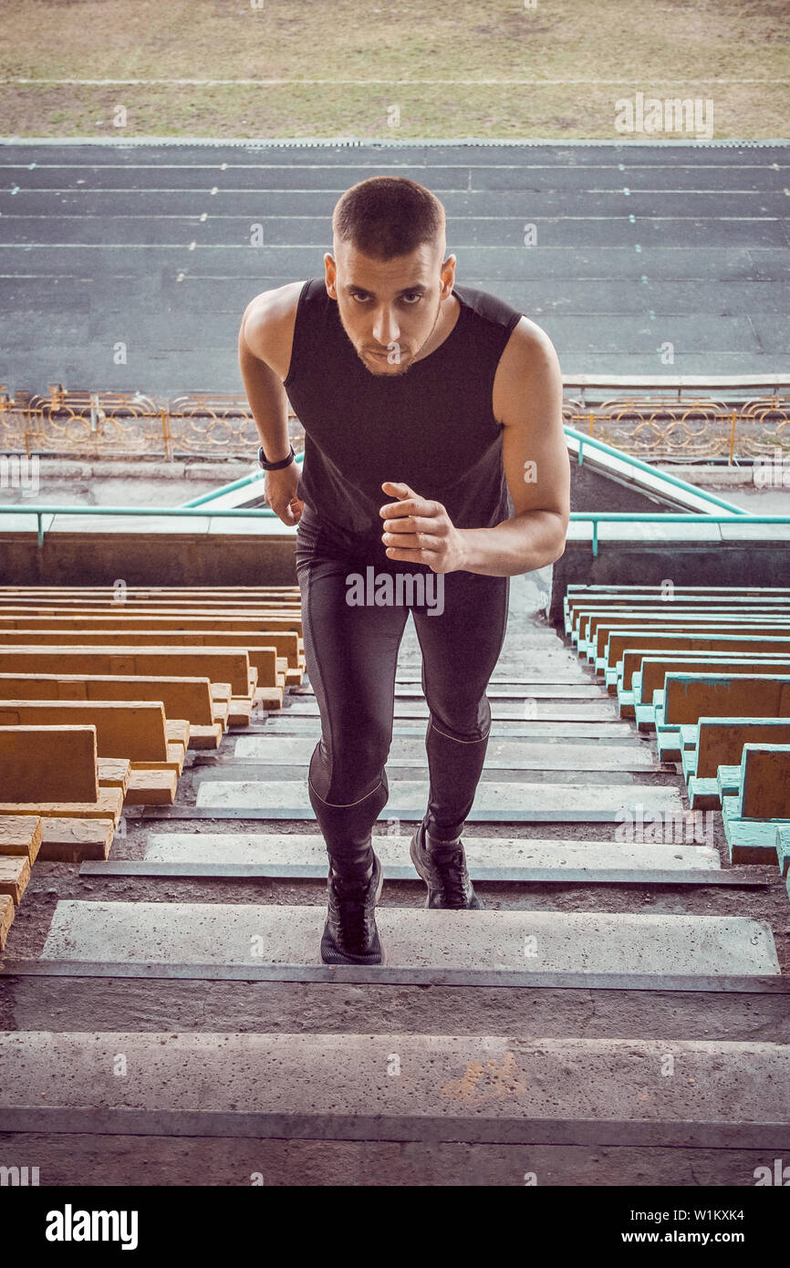 Caucasian man trains in running on the stairs. Track and field runner ...