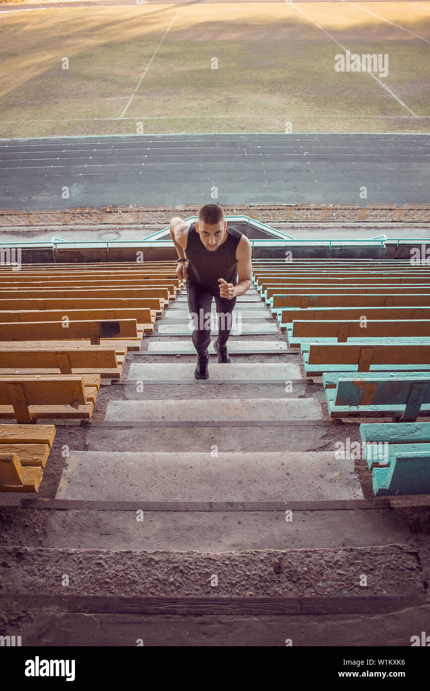 Caucasian man trains in running on the stairs. Track and field runner ...