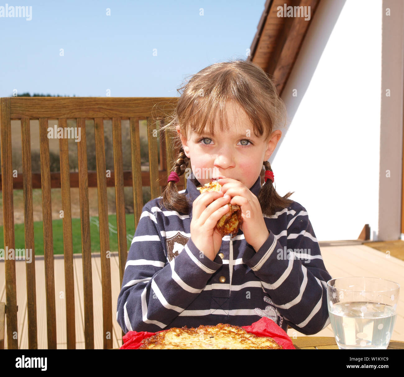 Little girl eating potato pancake Stock Photo - Alamy