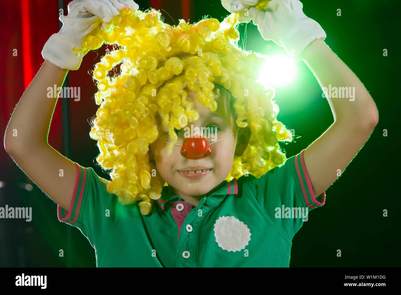 Little boy clown. Child in a clown wig with a red nose close up Stock ...
