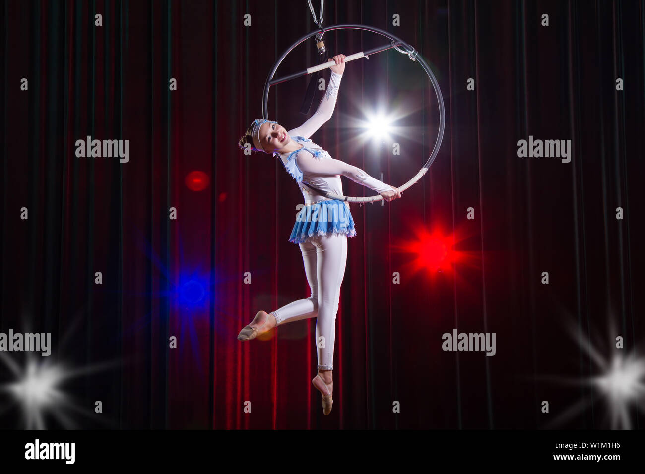 Performs a circus girl actress. Circus aerial gymnast on the hoop ...