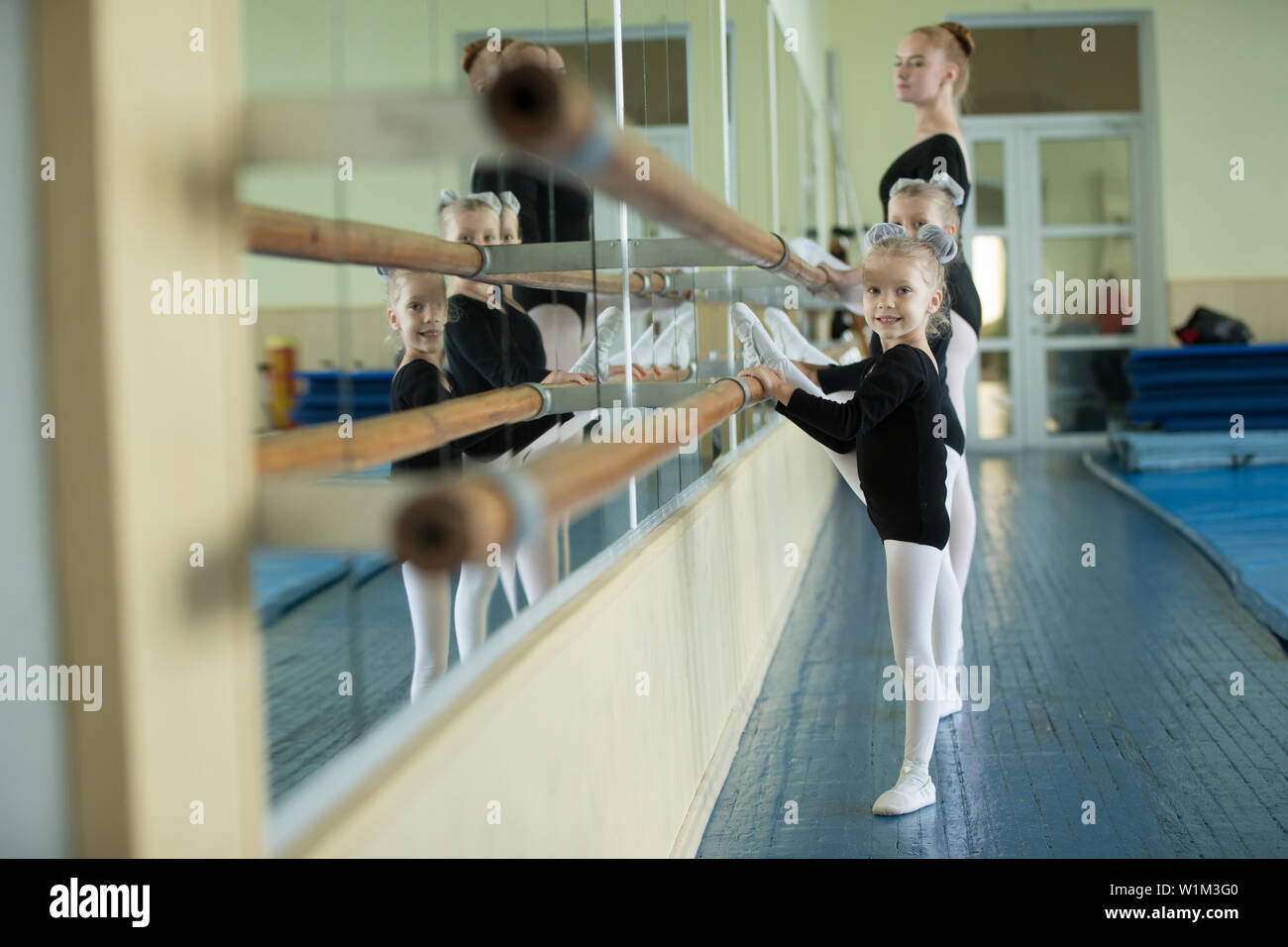 Little girls at the ballet machine. Lesson choreography. Young ...