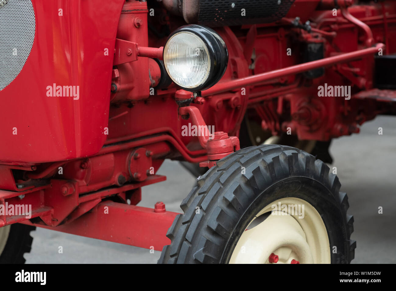 description: A detailed close up of an old messy red vintage tractor ...