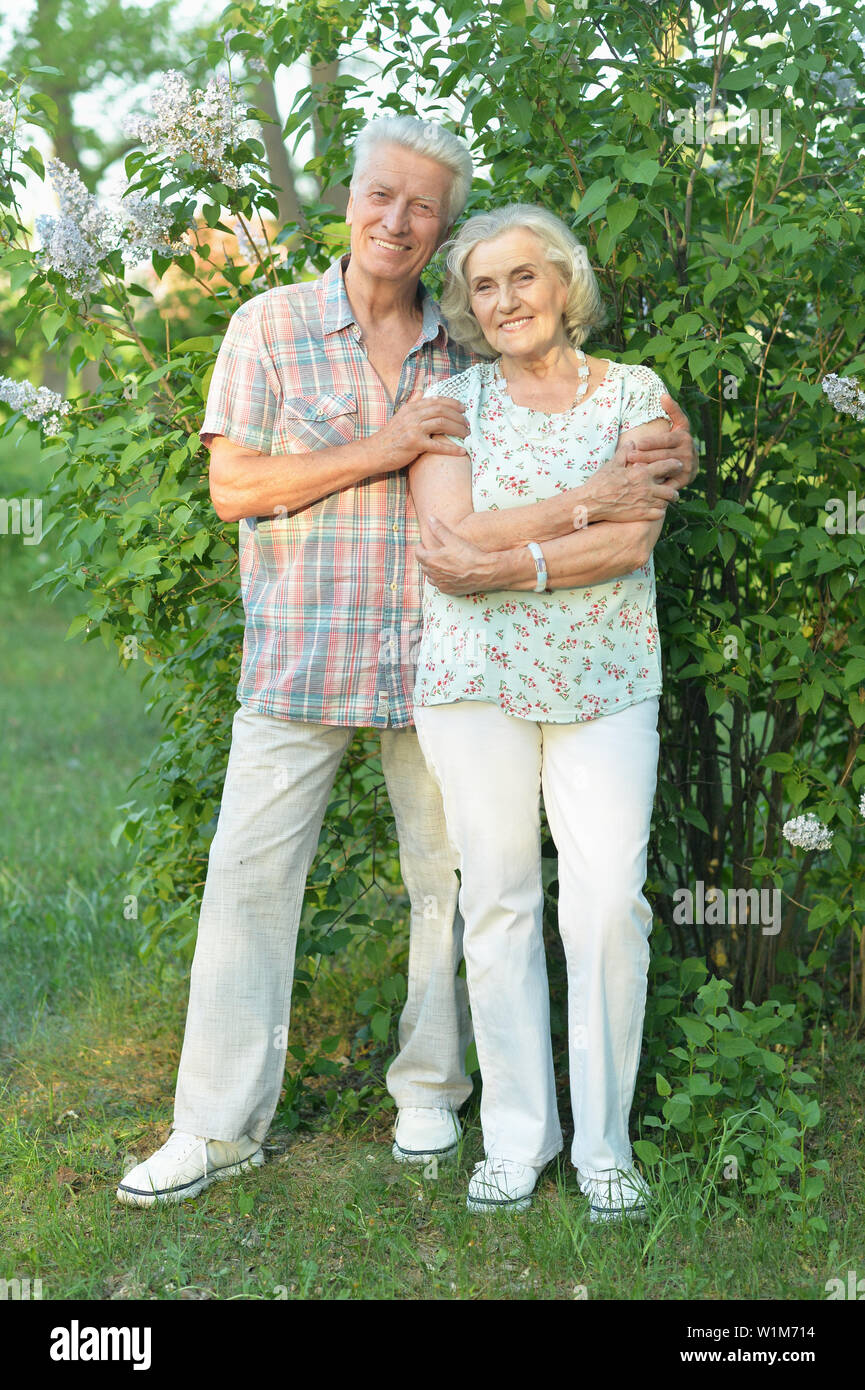 Portrait Of Beautiful Senior Couple Hugging In The Park By Lilacs Stock