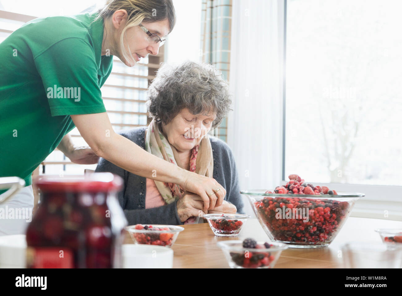 Nurse preparing food with senior woman in rest home Stock Photo - Alamy
