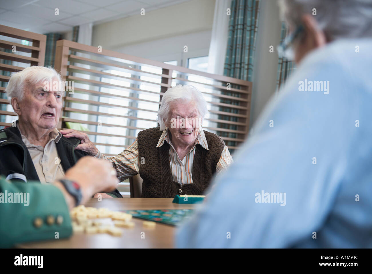 Senior inhabitants having fun playing board game in rest home Stock ...