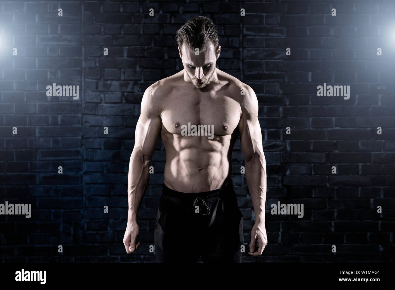 Handsome muscular man looking down Stock Photo - Alamy