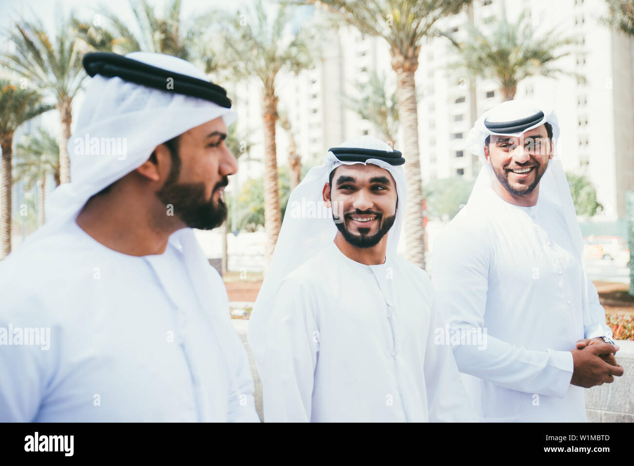 Group of businessmen talking on the street in Dubai Stock Photo - Alamy