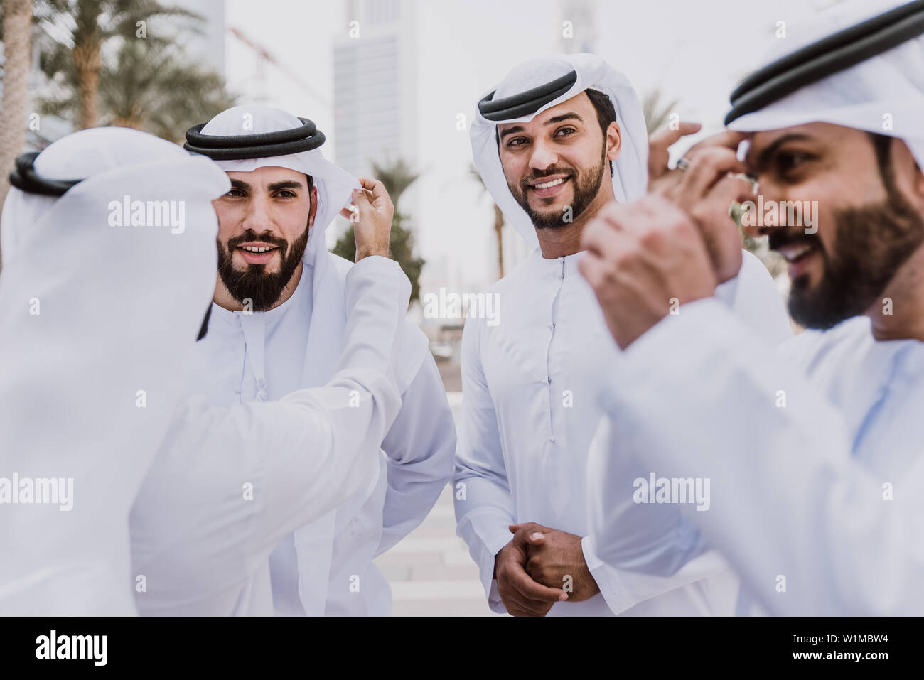 Group of businessmen talking on the street in Dubai Stock Photo - Alamy