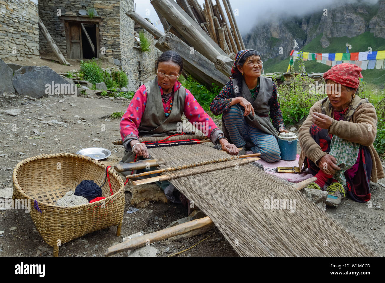 Women weaving on a simple weaving loom on the ground in Nar, Nepal ...