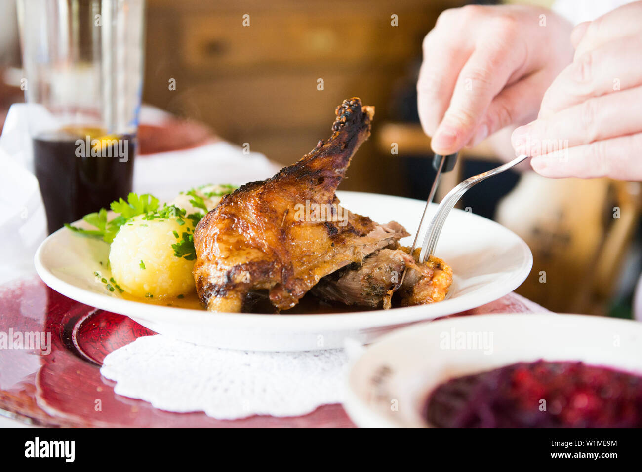 Man eating duck meat with potato dumpling at restaurant table, Bavaria ...
