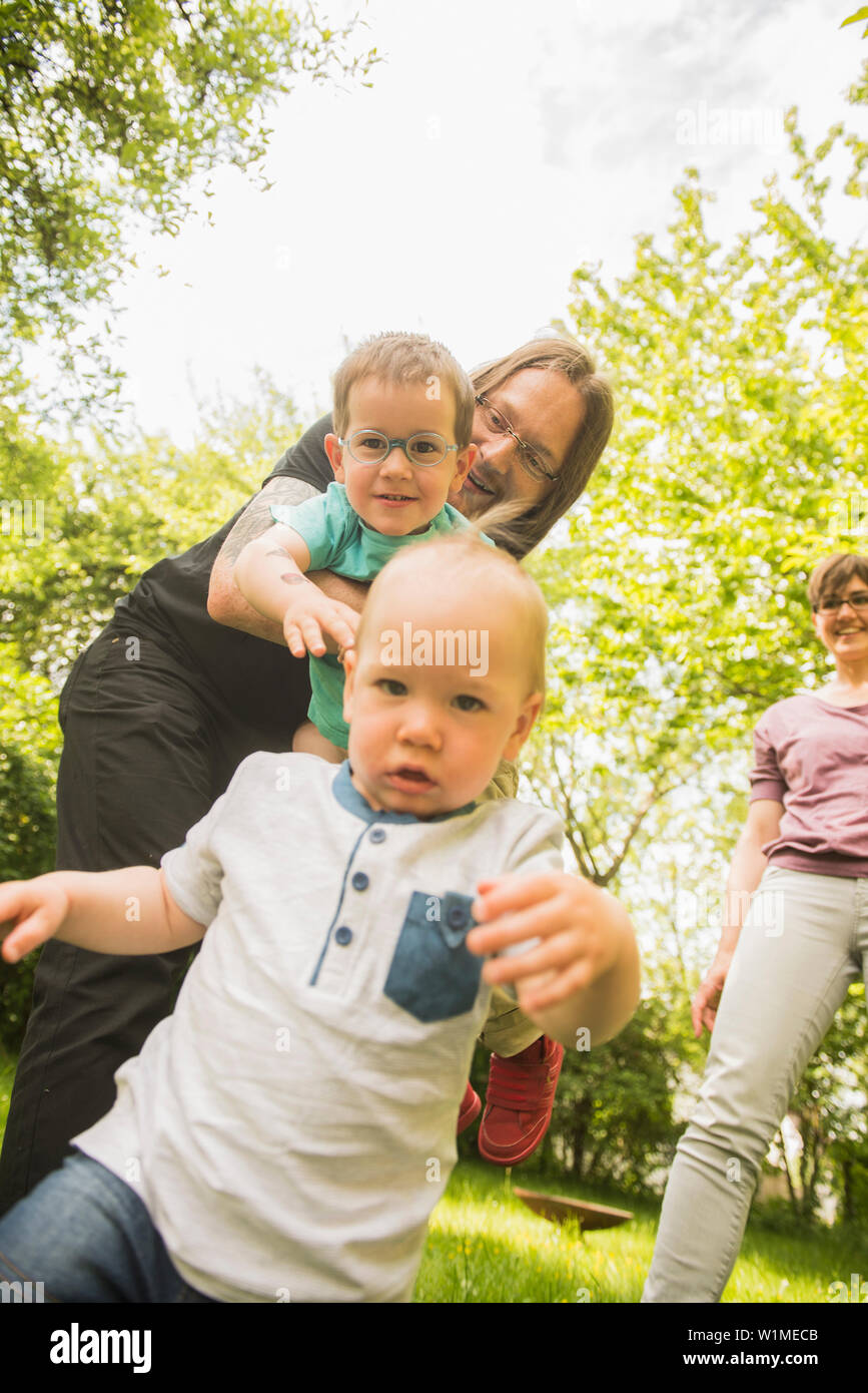 Parents having fun with children at the garden Stock Photo - Alamy