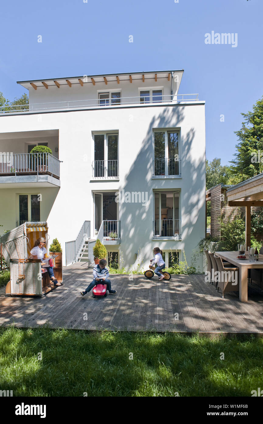 Mother and two children on terrace of a one family house, Hamburg ...