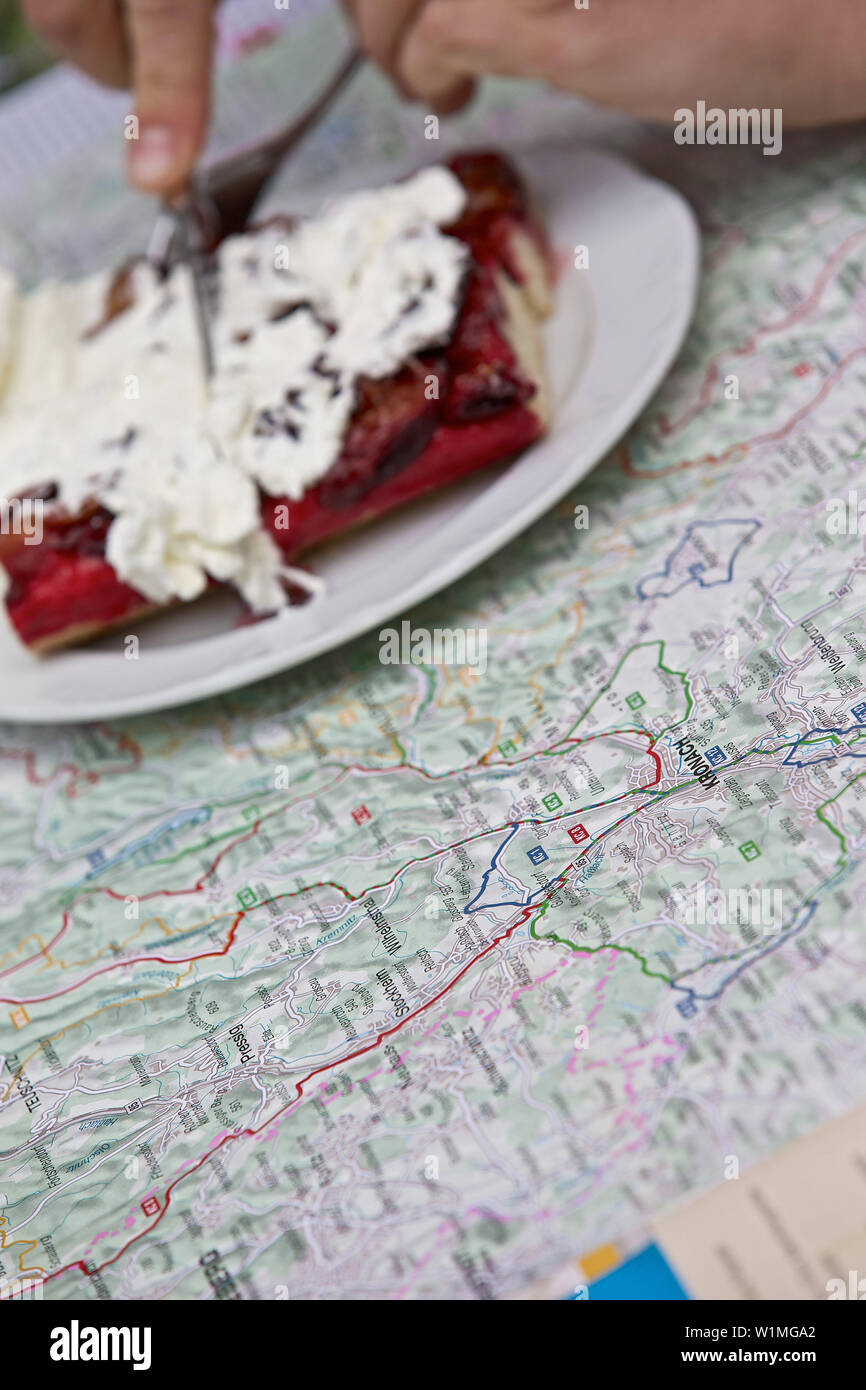 Person eating a delicious cake and looking at a map Stock Photo - Alamy