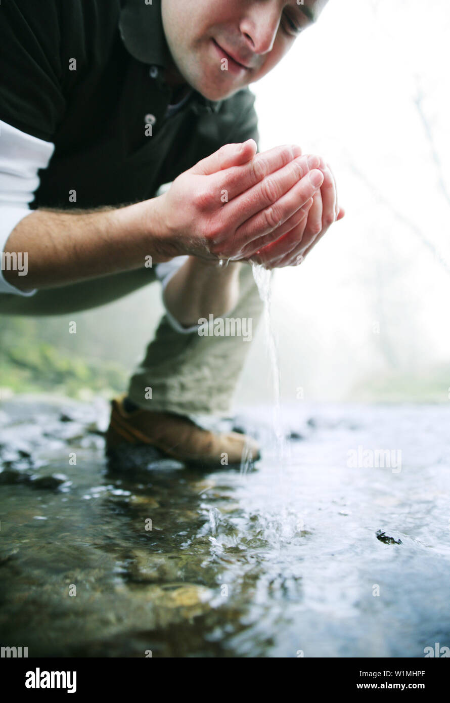 Man drinking water from a stream Stock Photo - Alamy
