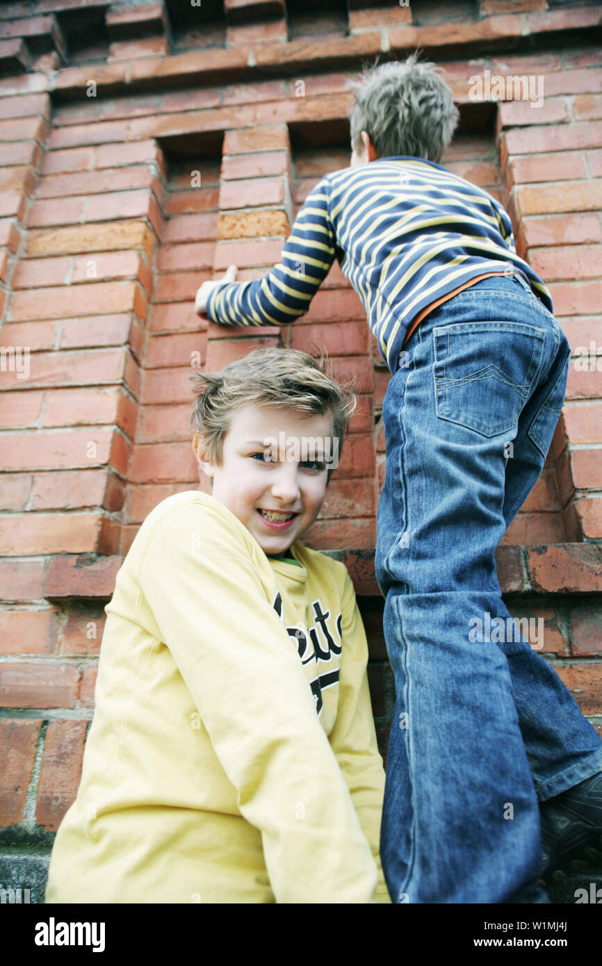 Boy climbing over wall hi-res stock photography and images - Alamy