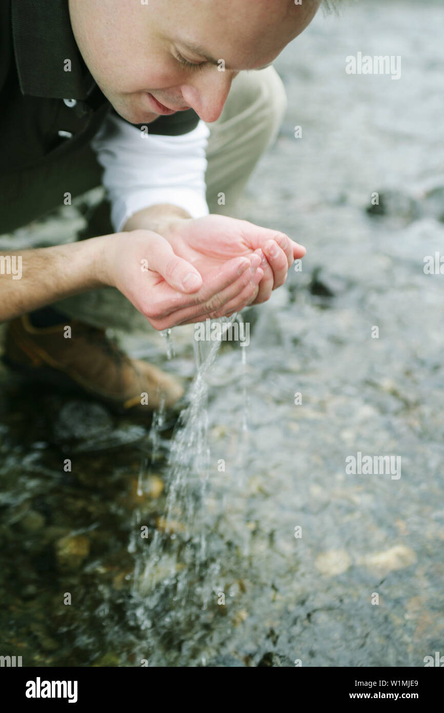 Man drinking water from a stream Stock Photo - Alamy