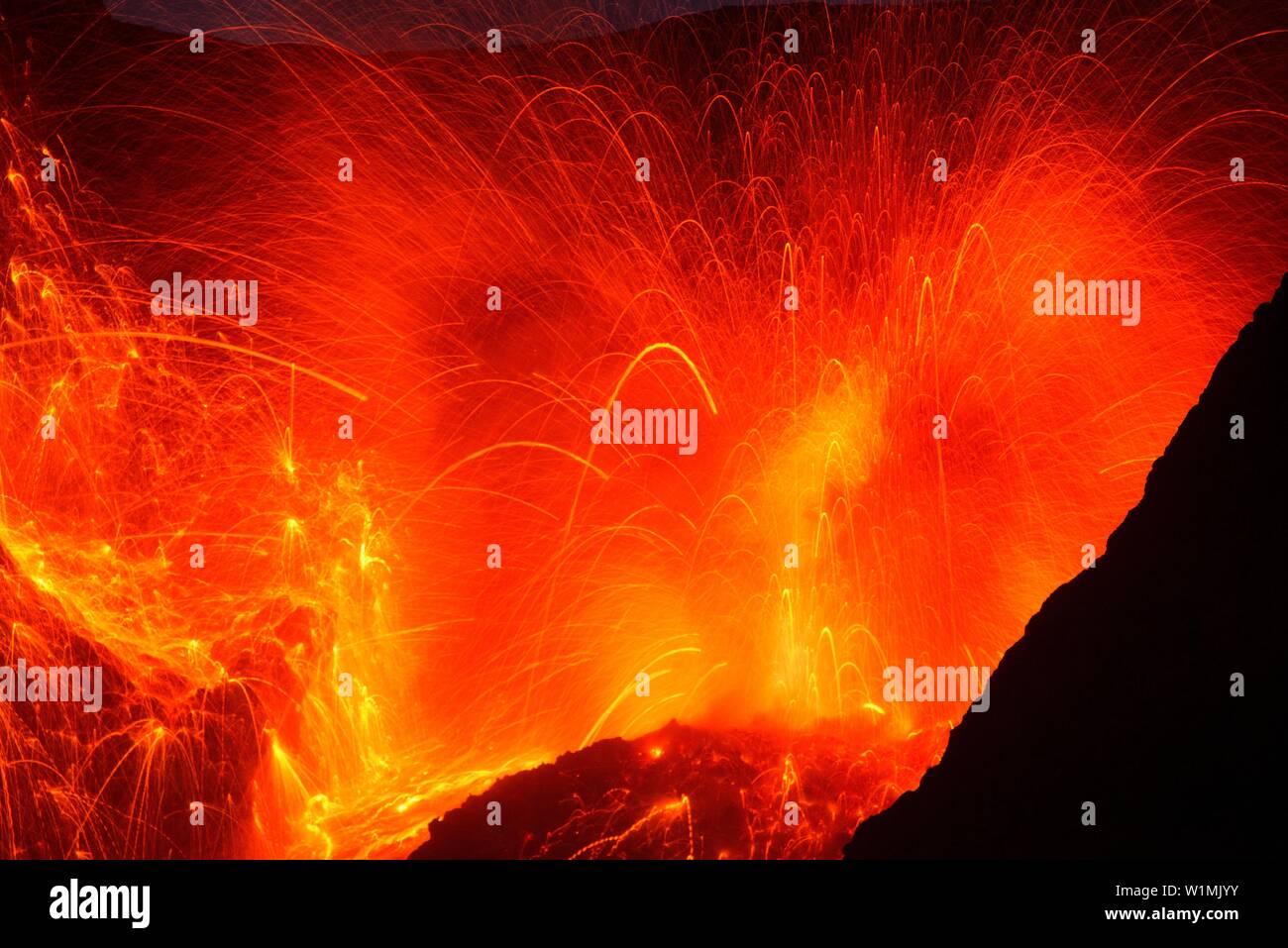 Close up of a huge eruption of Batu Tara volcano with lava bombs during ...