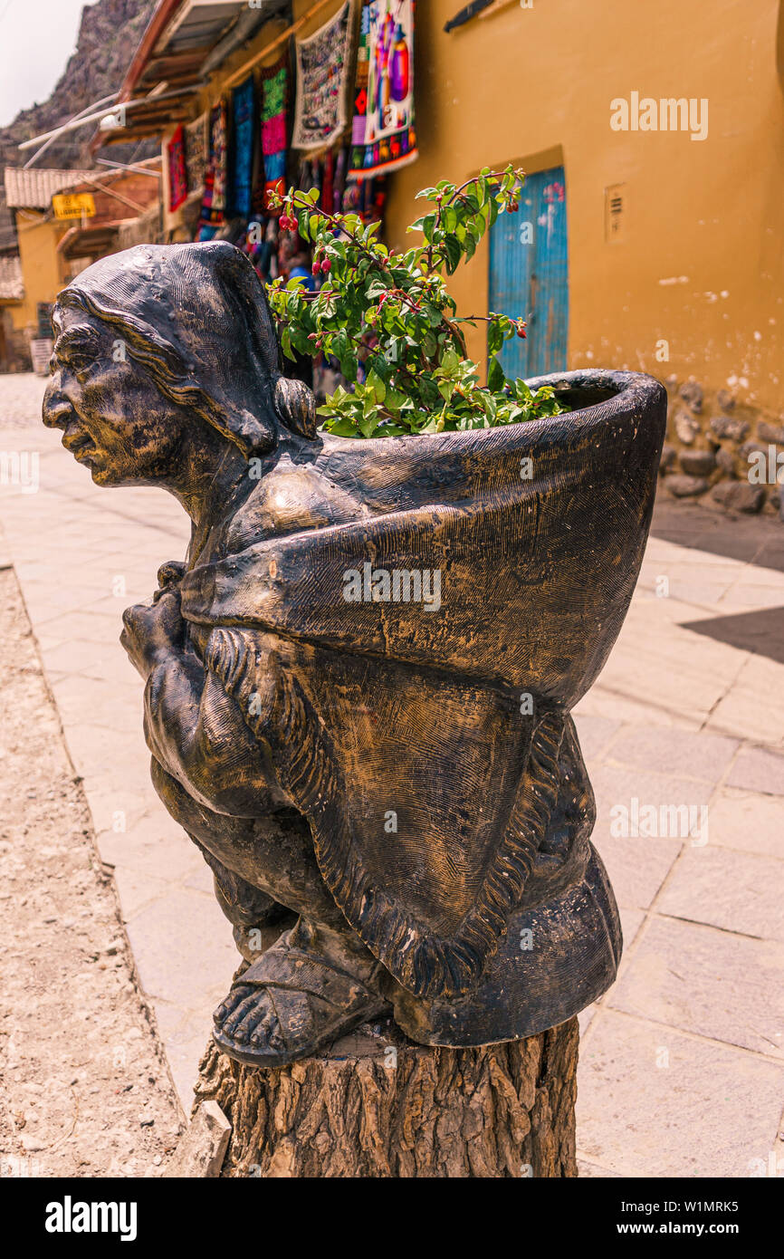 Bronze statue of a local woman in Ollantaytambo carrying flower, Peru ...