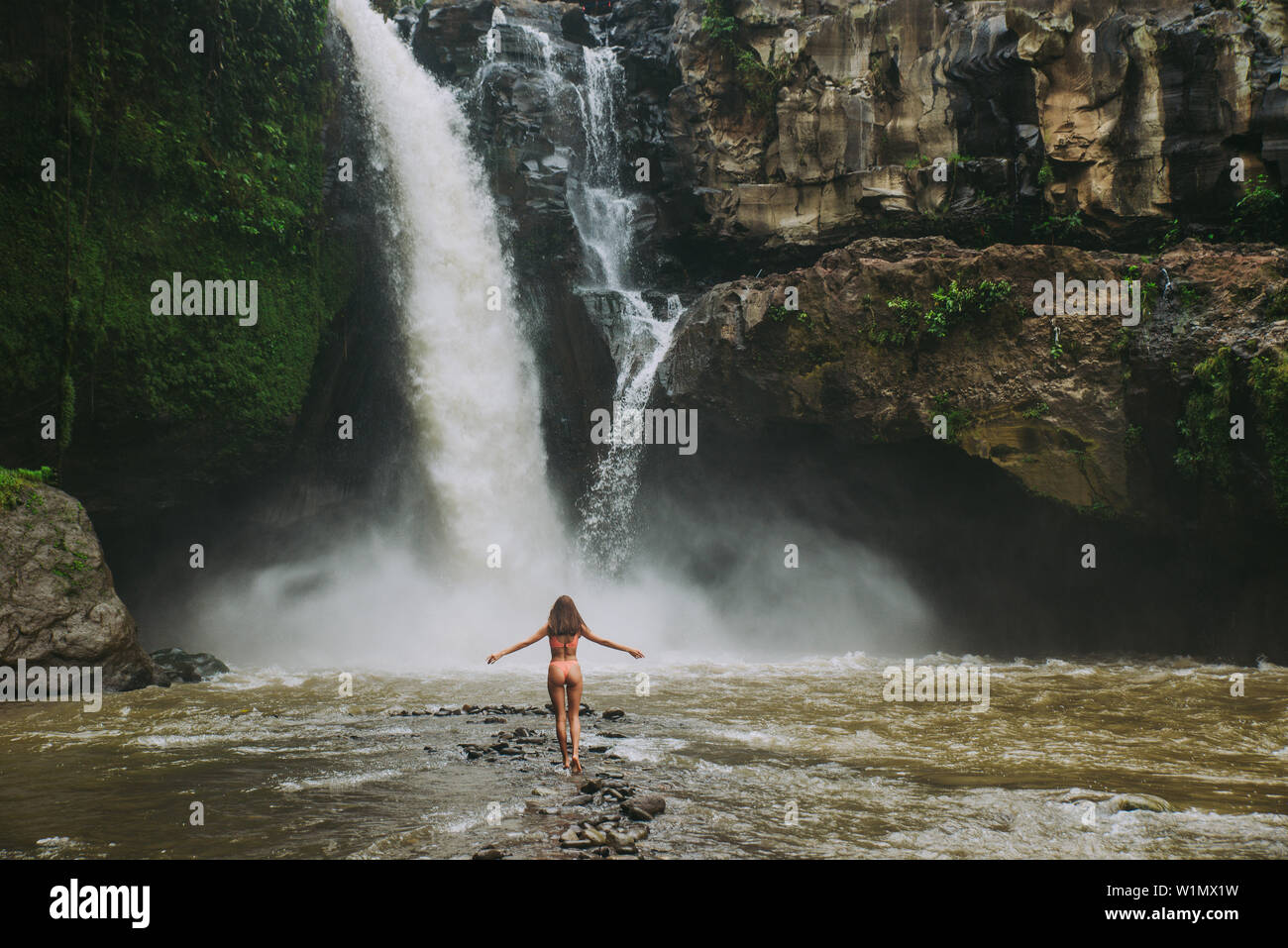 Beautiful girl having fun at the waterfalls in Bali. Concept about ...