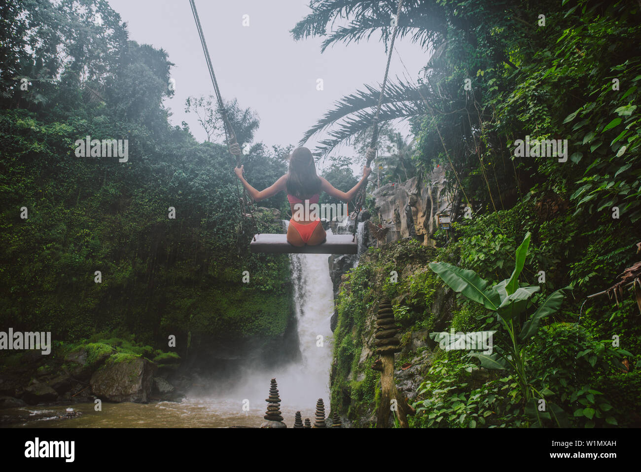 Beautiful girl having fun at the waterfalls in Bali. Concept about ...