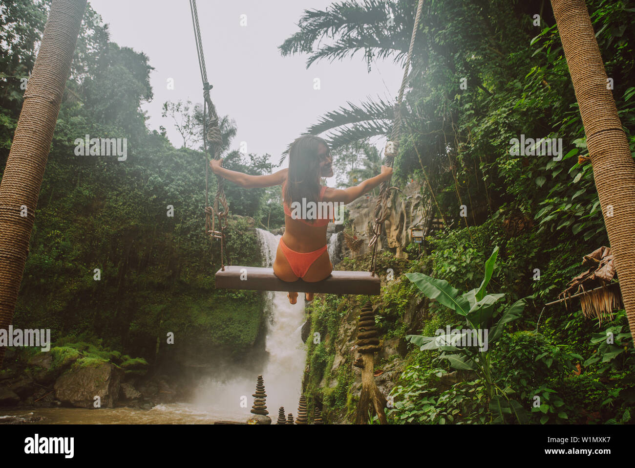 Beautiful girl having fun at the waterfalls in Bali. Concept about ...