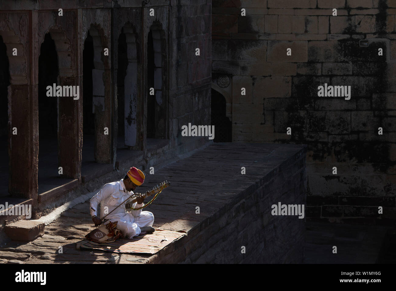Man playing on a Esraj near the walls of the Meherangarh fort, Jodhpur ...
