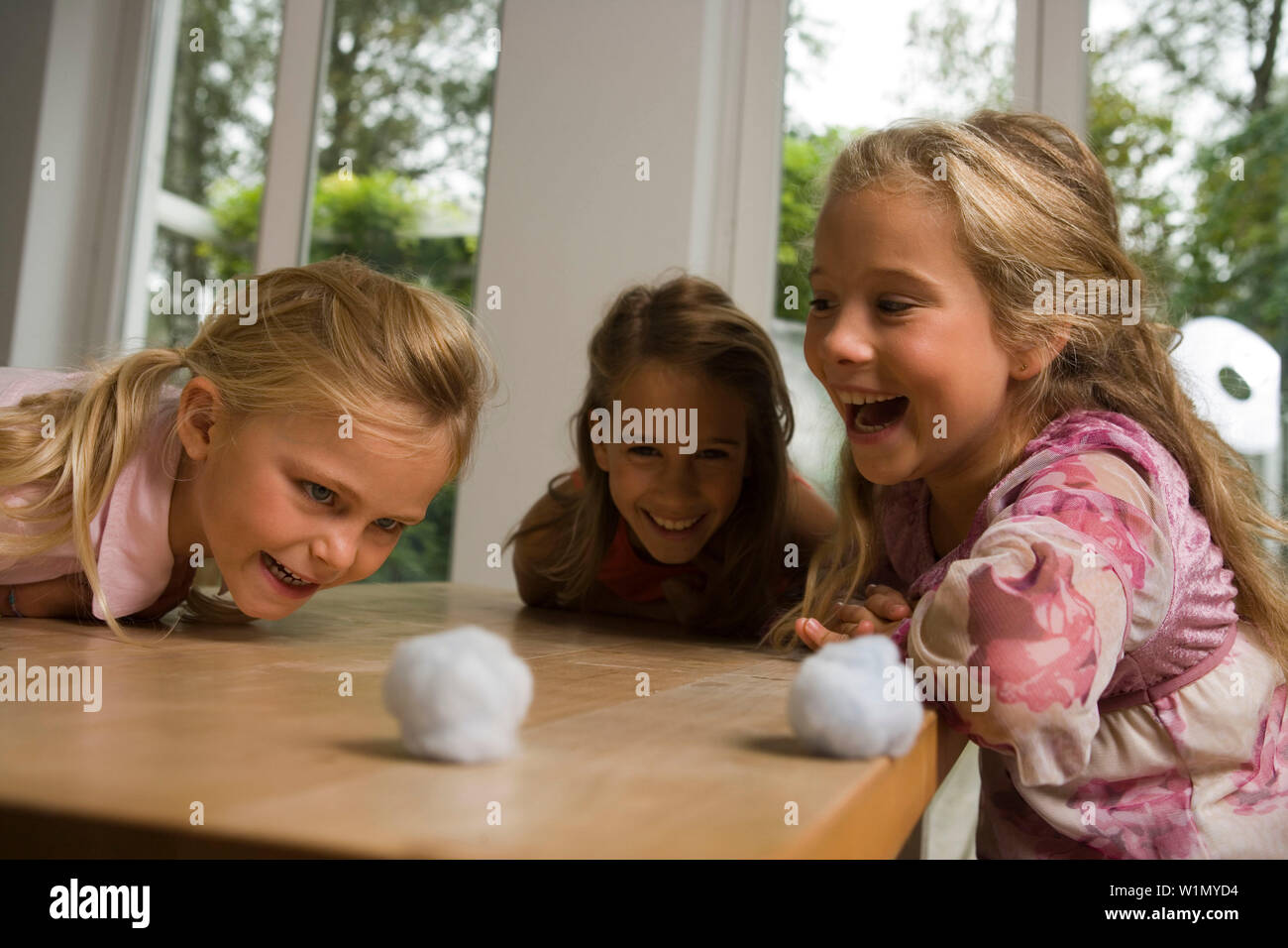 Three girls playing Blowing Cotton Wool, children's birthday party ...