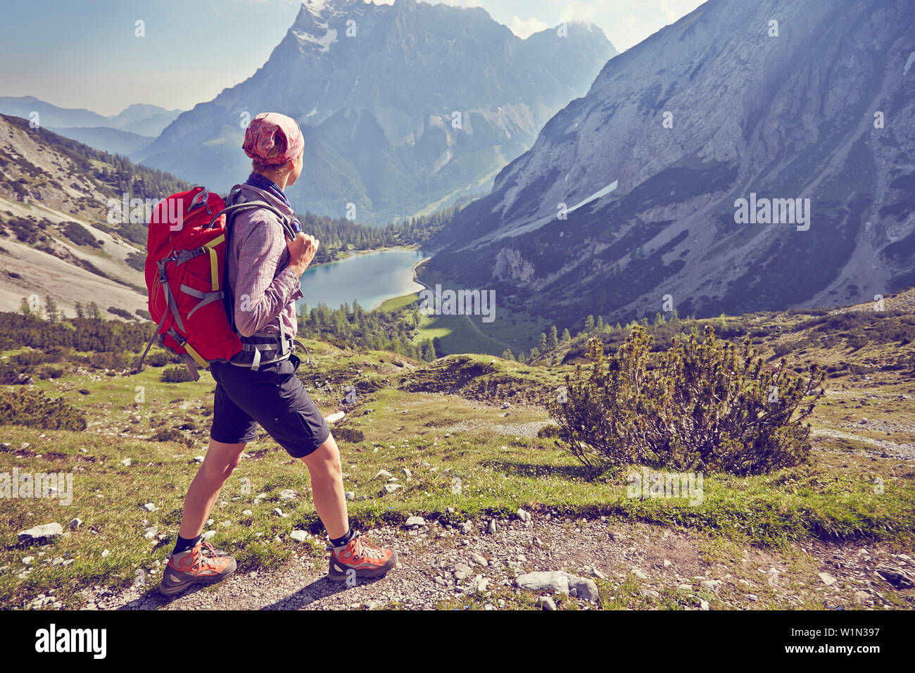 Woman hiking looking down the valley Stock Photo - Alamy