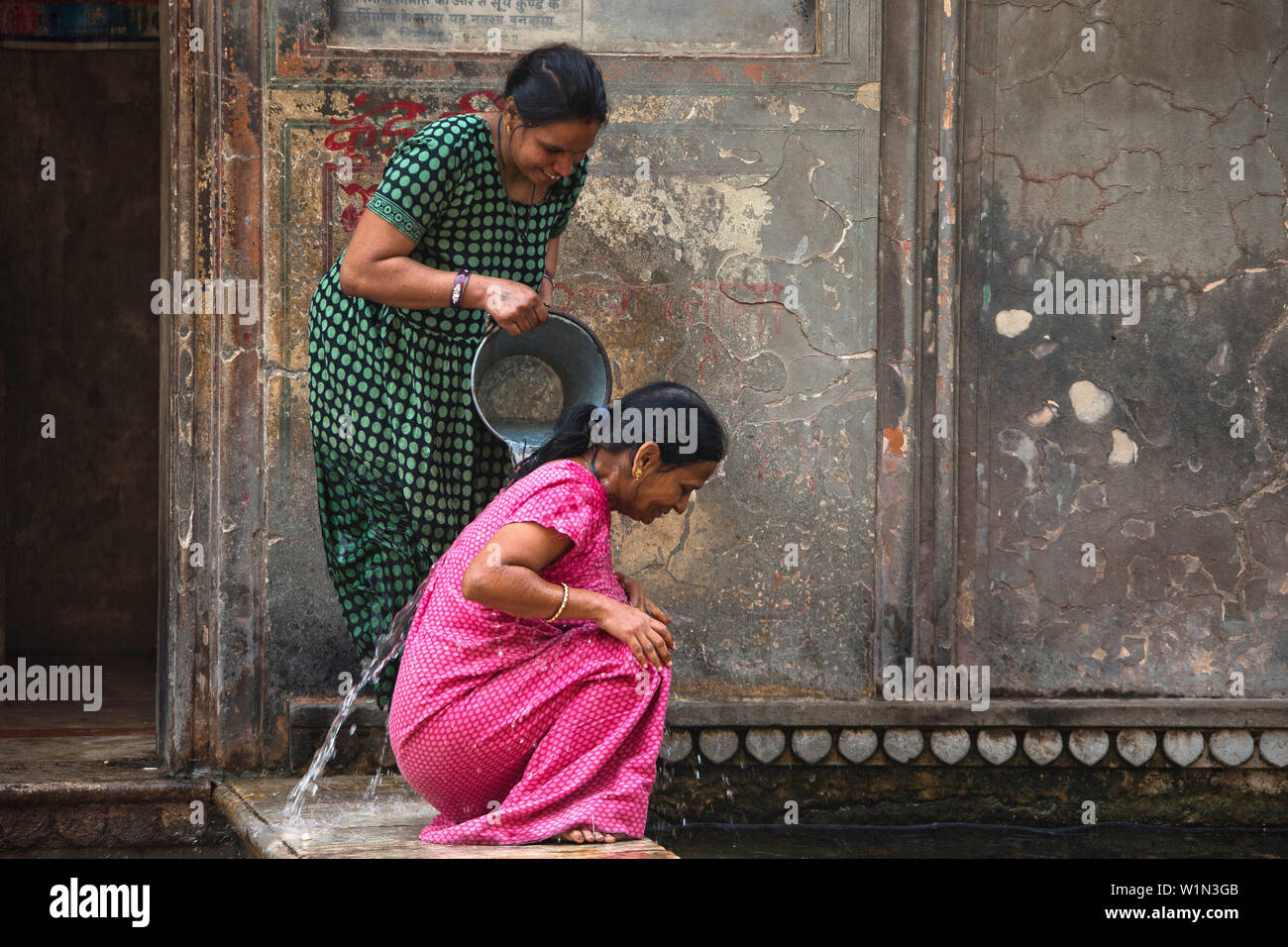 Two women having a ritual bath in Galtaji temple, Jaipur, Rajasthan ...