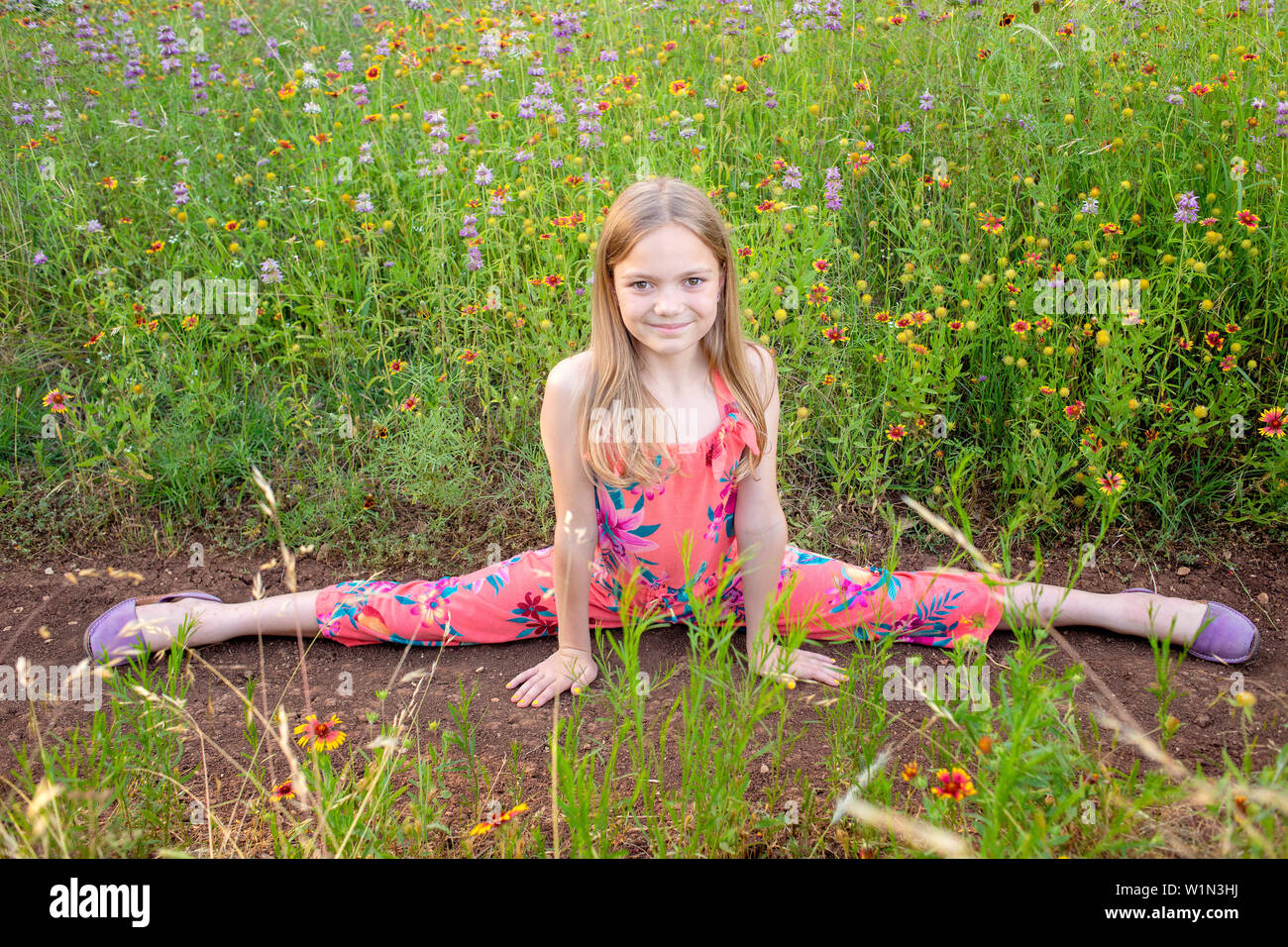 Girl doing a split in the wildflowers Stock Photo - Alamy
