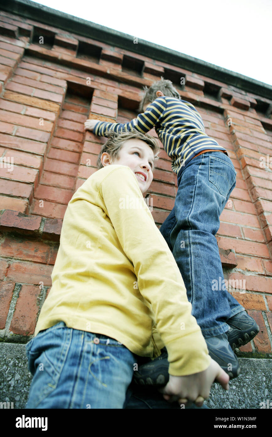 Boy climbing over wall hi-res stock photography and images - Alamy