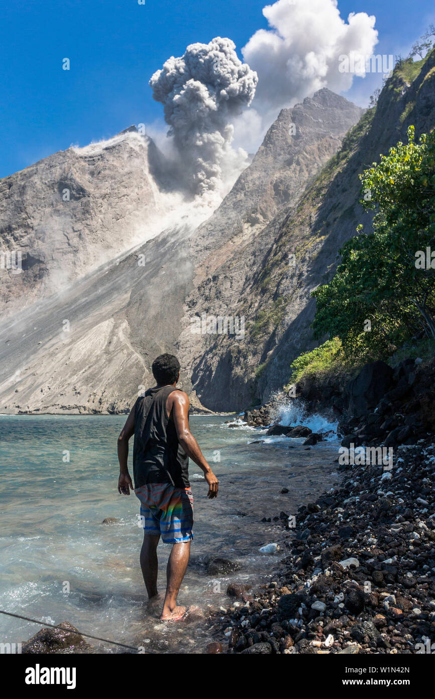 Man standing at the foot of active Batu Tara of Batu Tara volcano ...